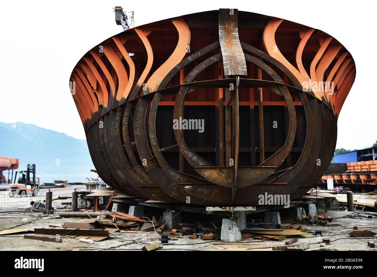 Staff work to produce a large vessel at a ship factory along the ...