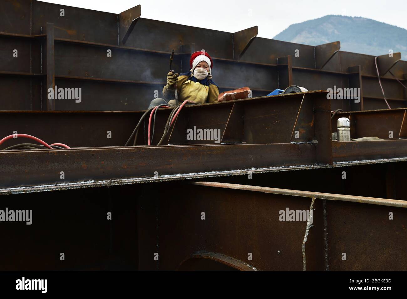 Staff work to produce a large vessel at a ship factory along the ...