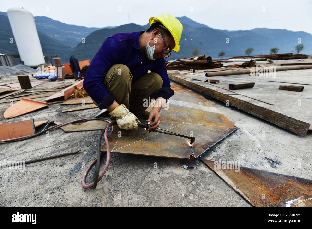 Staff work to produce a large vessel at a ship factory along the ...