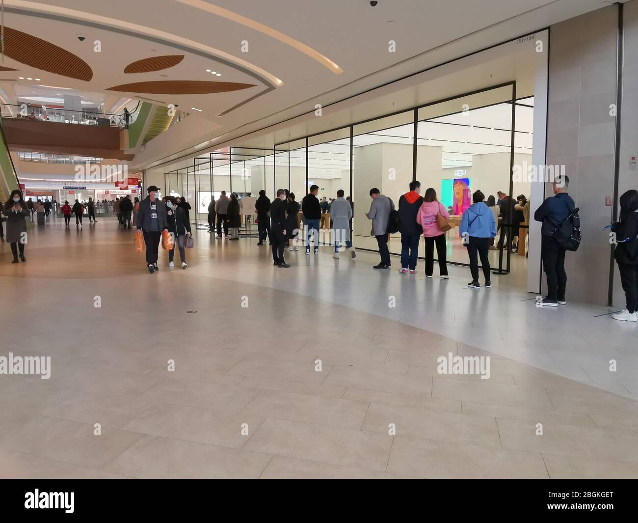 People line up outside a shopping mall to get inside in Qibao district ...