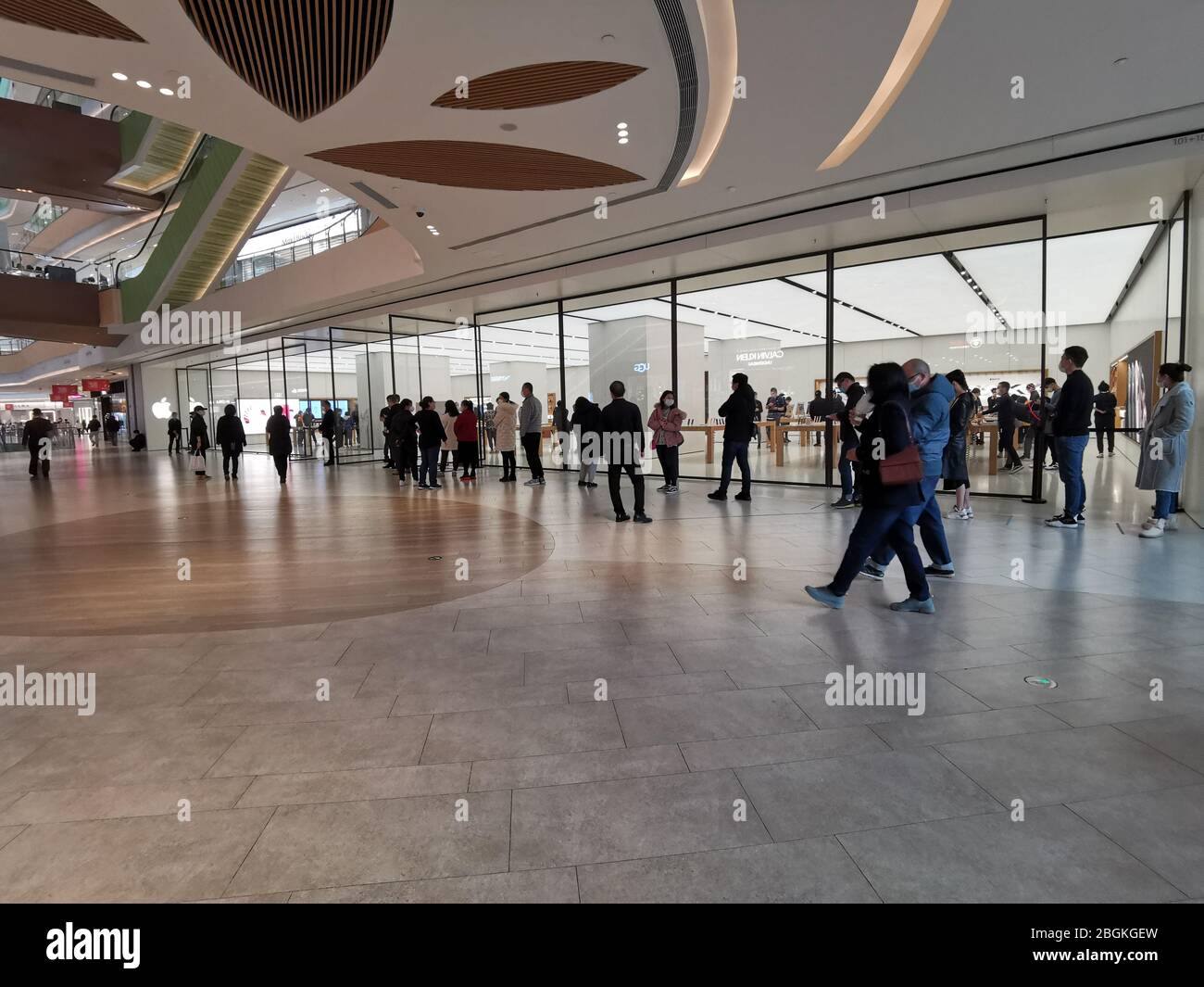 People line up outside a shopping mall to get inside in Qibao district ...