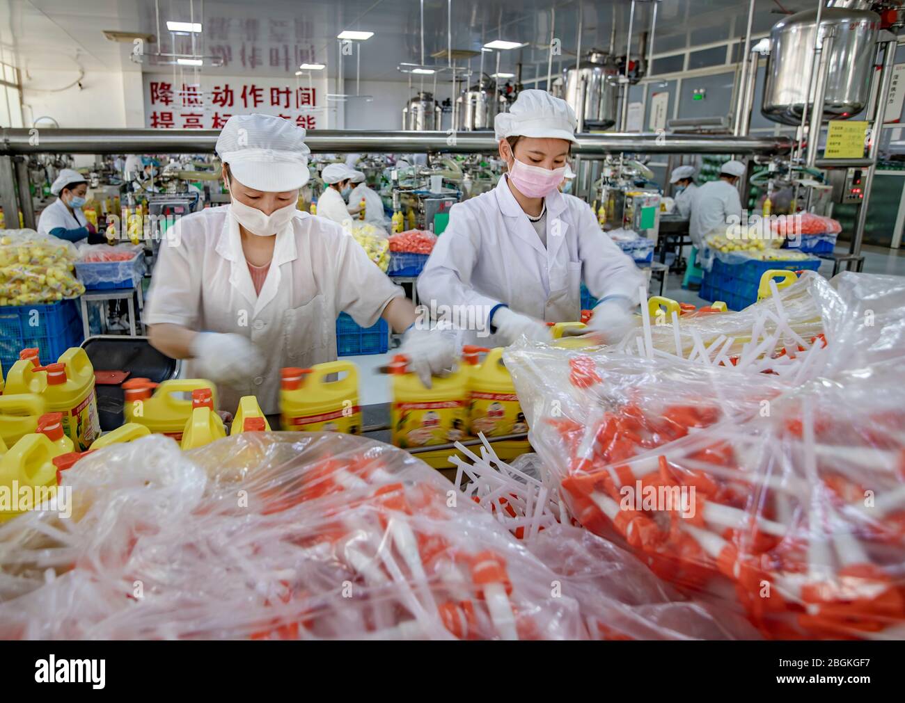 Workers labor to fill bottles with various cleaning products along ...