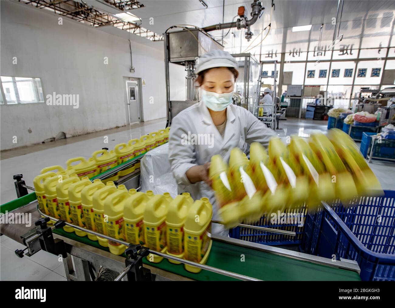 Workers labor to fill bottles with various cleaning products along ...
