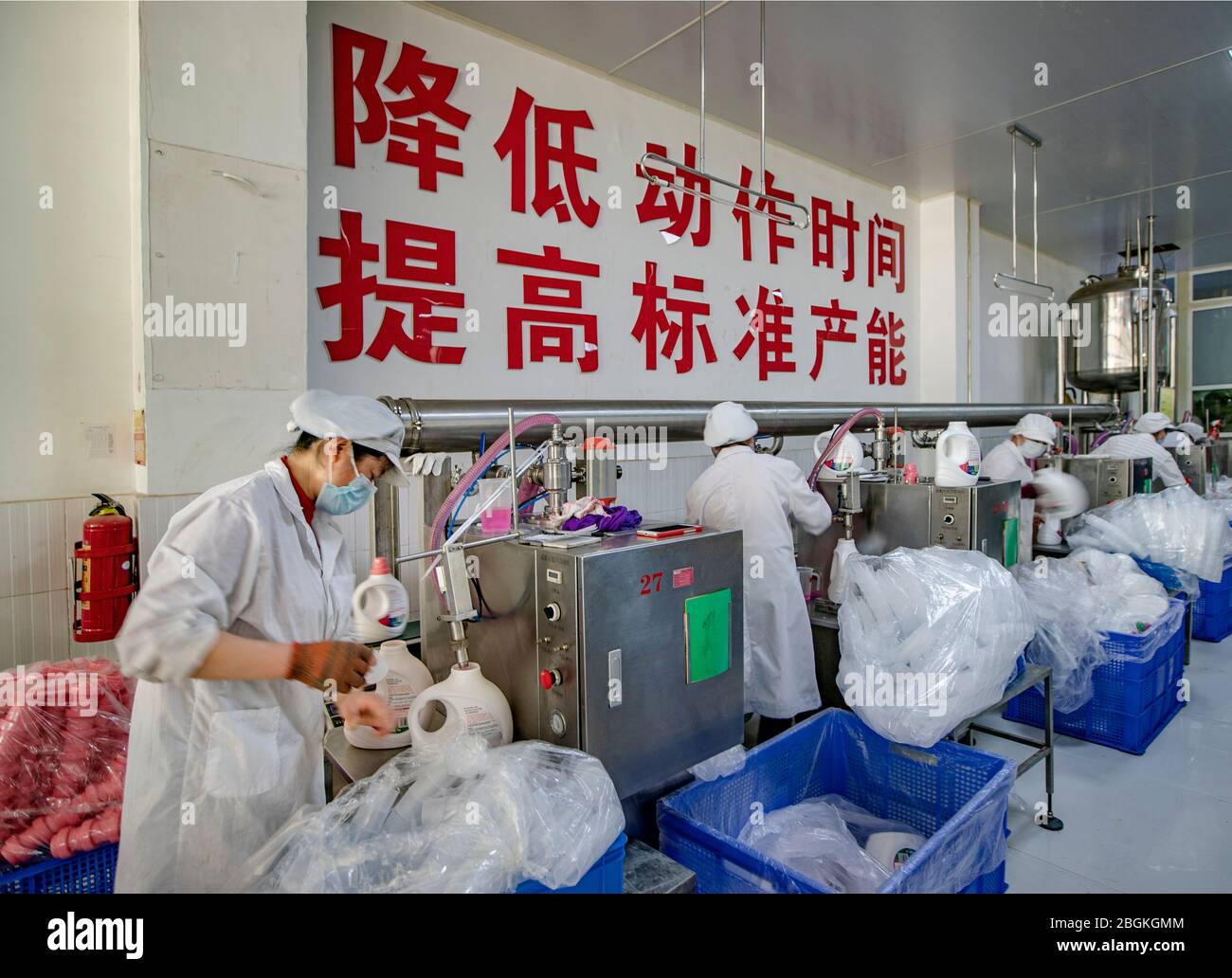 Workers labor to fill bottles with various cleaning products along ...