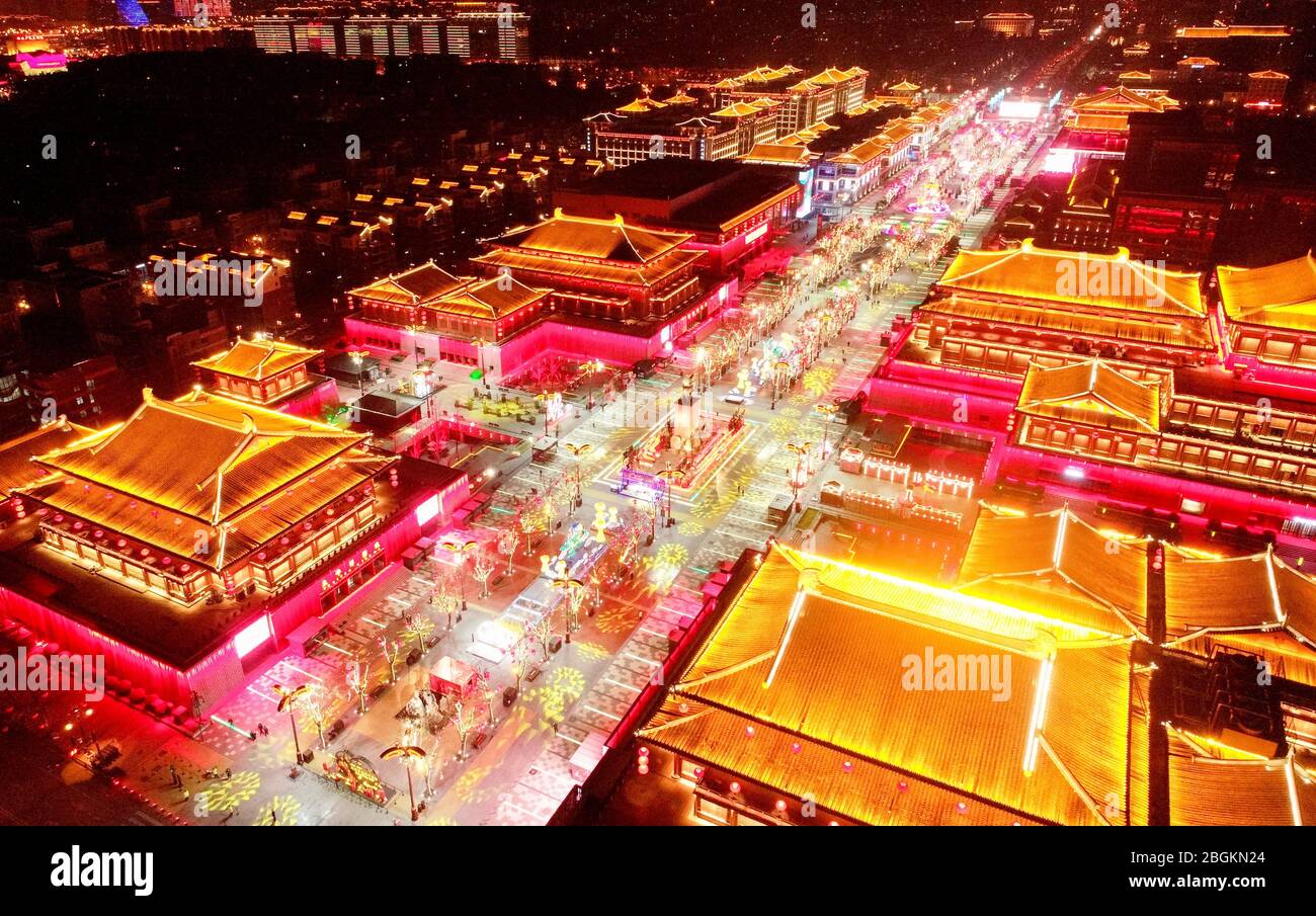 An aerial view of buildings and neon lights in various districts turn ...