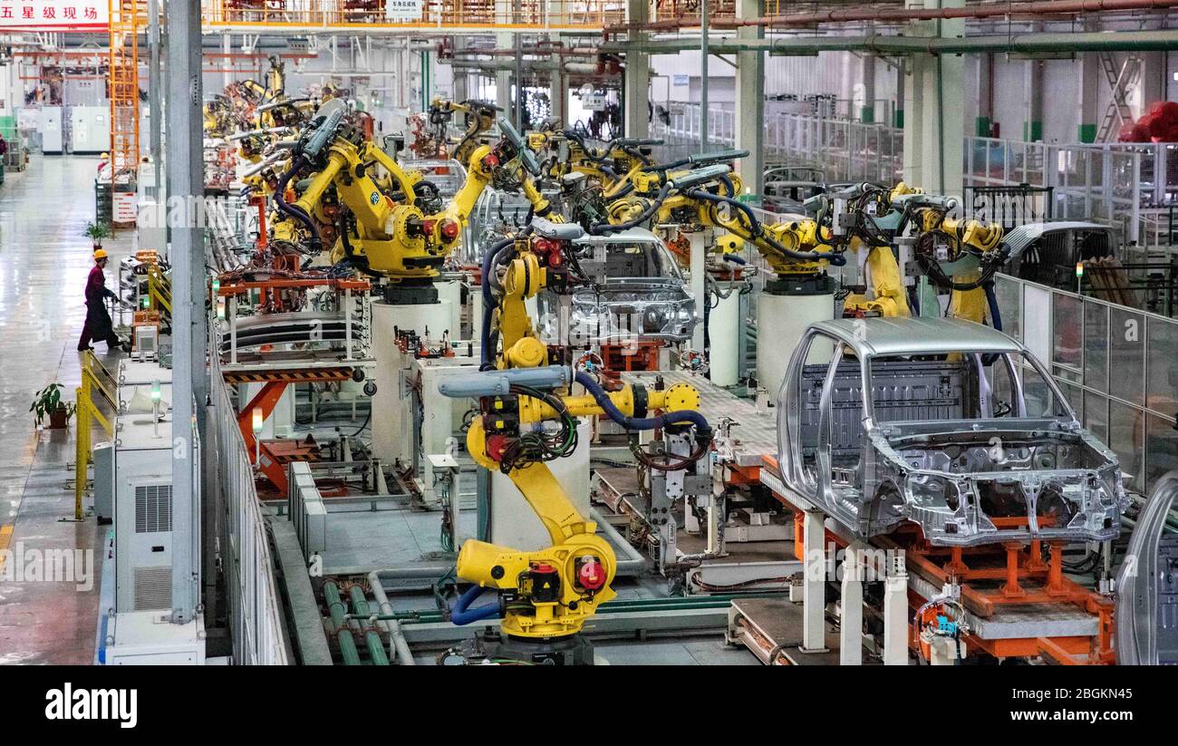 Mechanical arms are busy at assembling vehicles at a workshop of ...