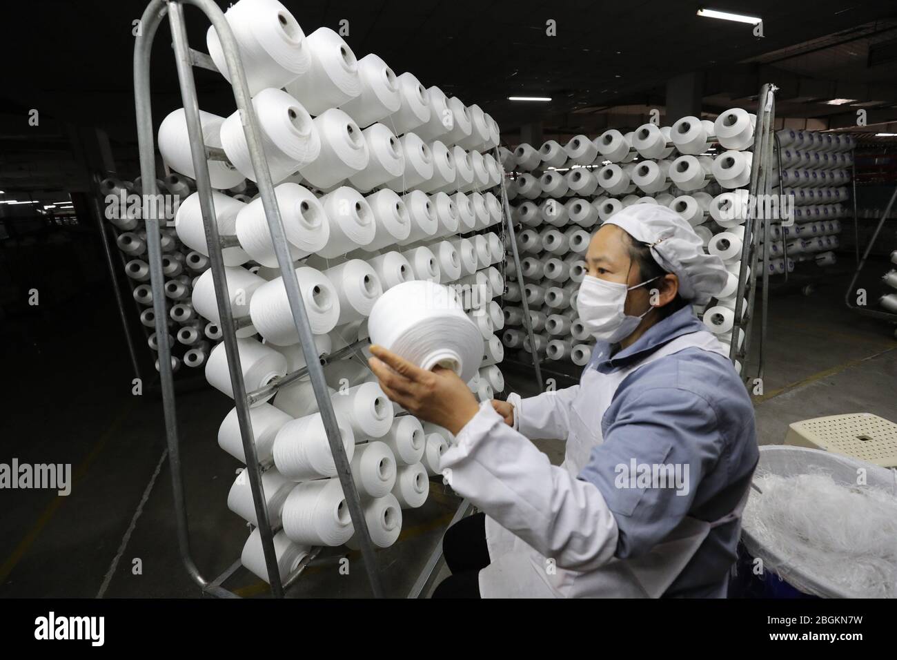 Staff at a local wire factory work to produce wire along automatic ...