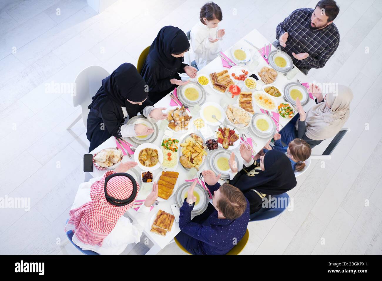 Eid Mubarak Muslim people praying before iftar dinner. Eating ...