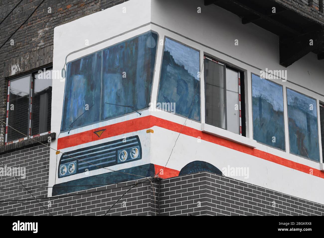 A mural of bus drawn on the wall of the second floor of a local ...