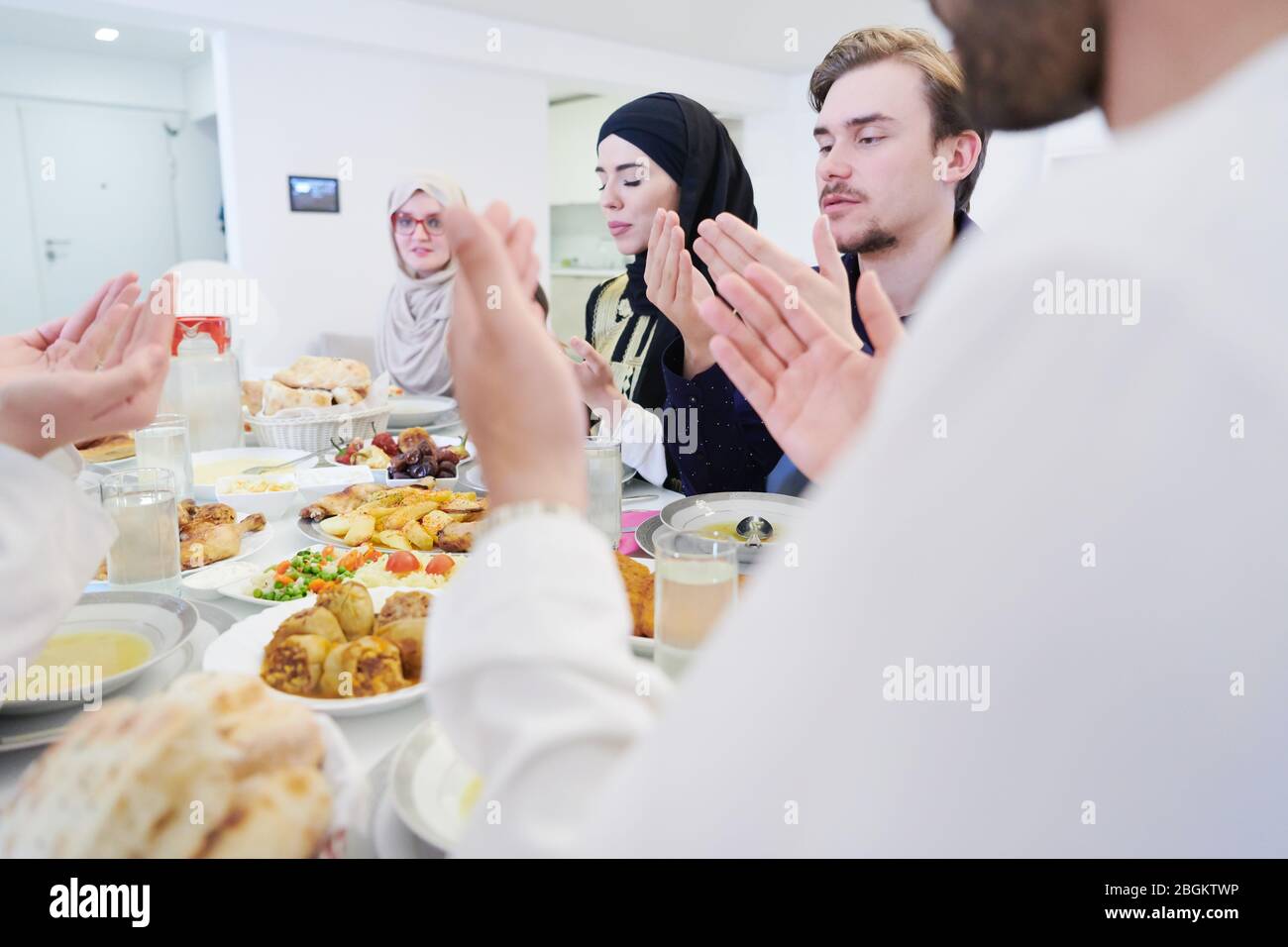Eid Mubarak Muslim people praying before iftar dinner. Eating ...