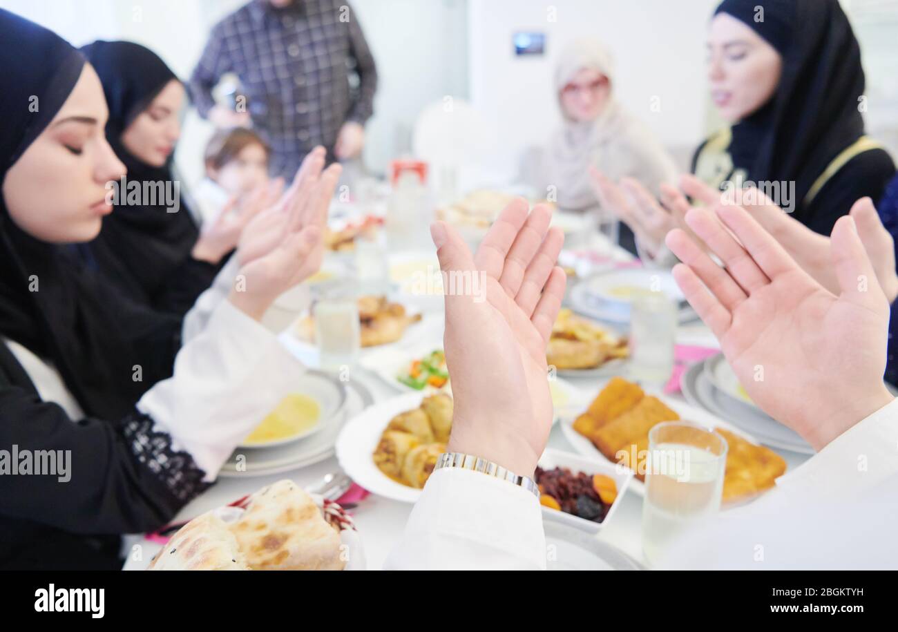 Eid Mubarak Muslim people praying before iftar dinner. Eating ...