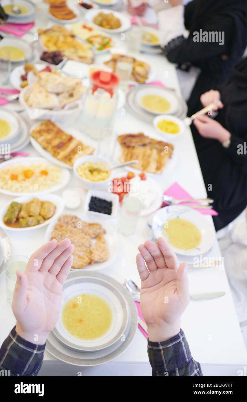 Eid Mubarak Muslim people praying before iftar dinner. Eating ...