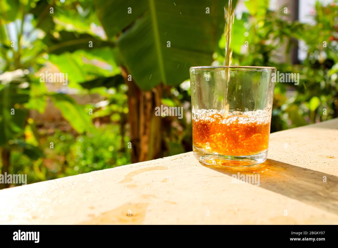 Outdoor Tea pouring into glass cup transparent with day sunlight Stock ...