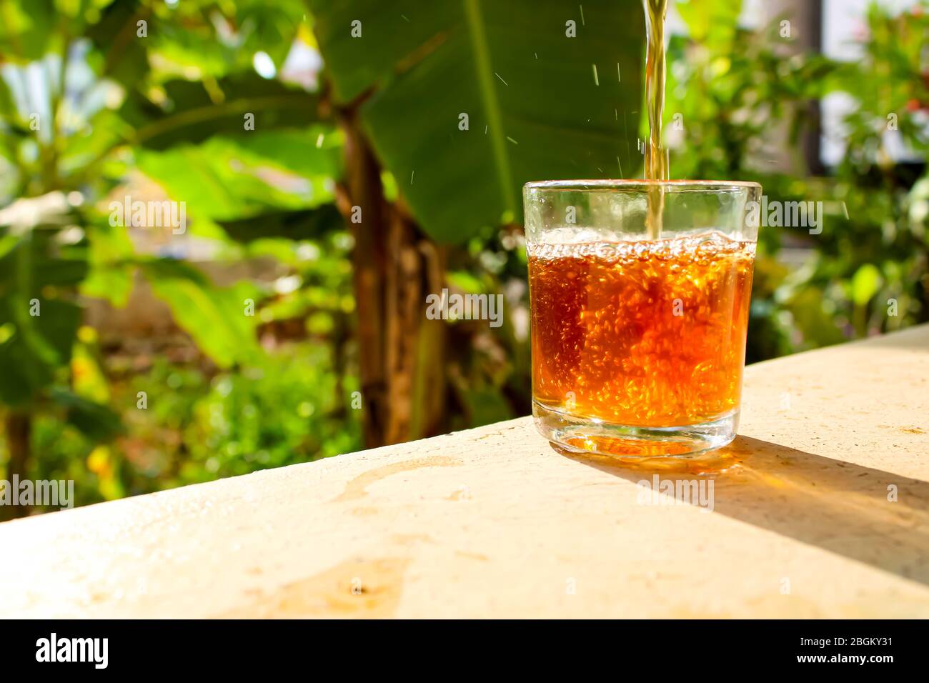 Outdoor Tea pouring into glass cup transparent with day sunlight Stock ...