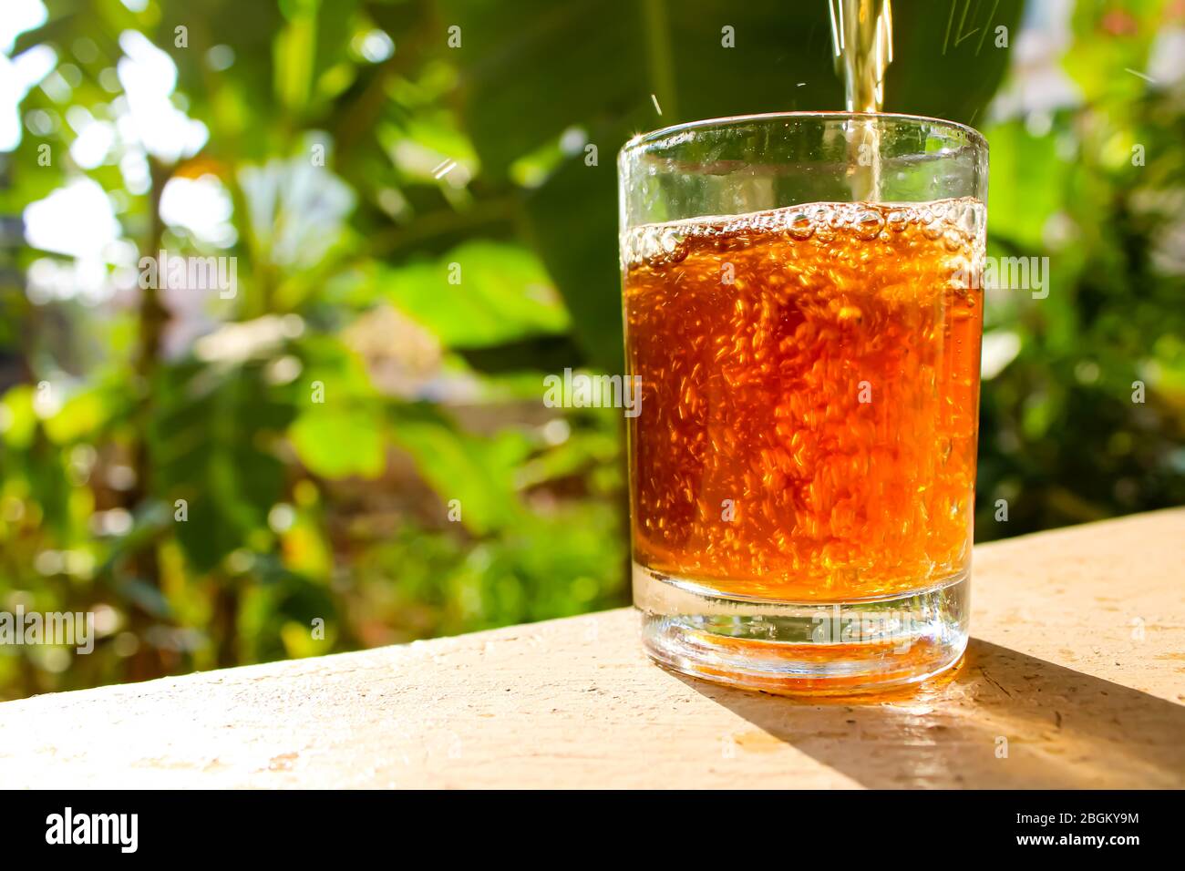 Outdoor Tea pouring into glass cup transparent with day sunlight Stock ...