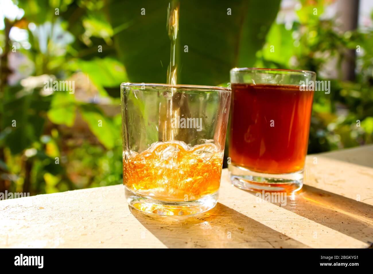 Outdoor Tea pouring into glass cup transparent with day sunlight Stock ...