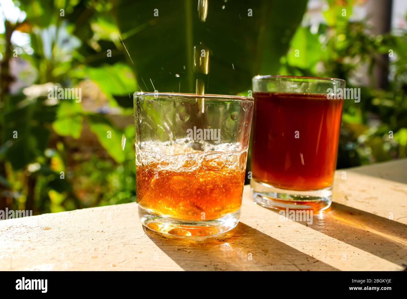 Outdoor Tea pouring into glass cup transparent with day sunlight Stock ...