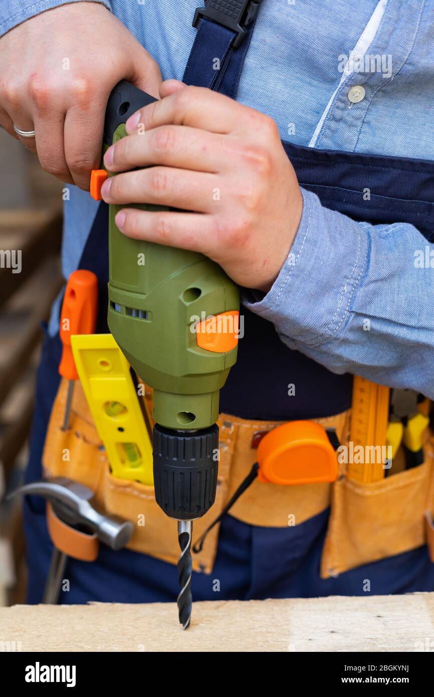 Close up picture of construction worker holding electric drill ...