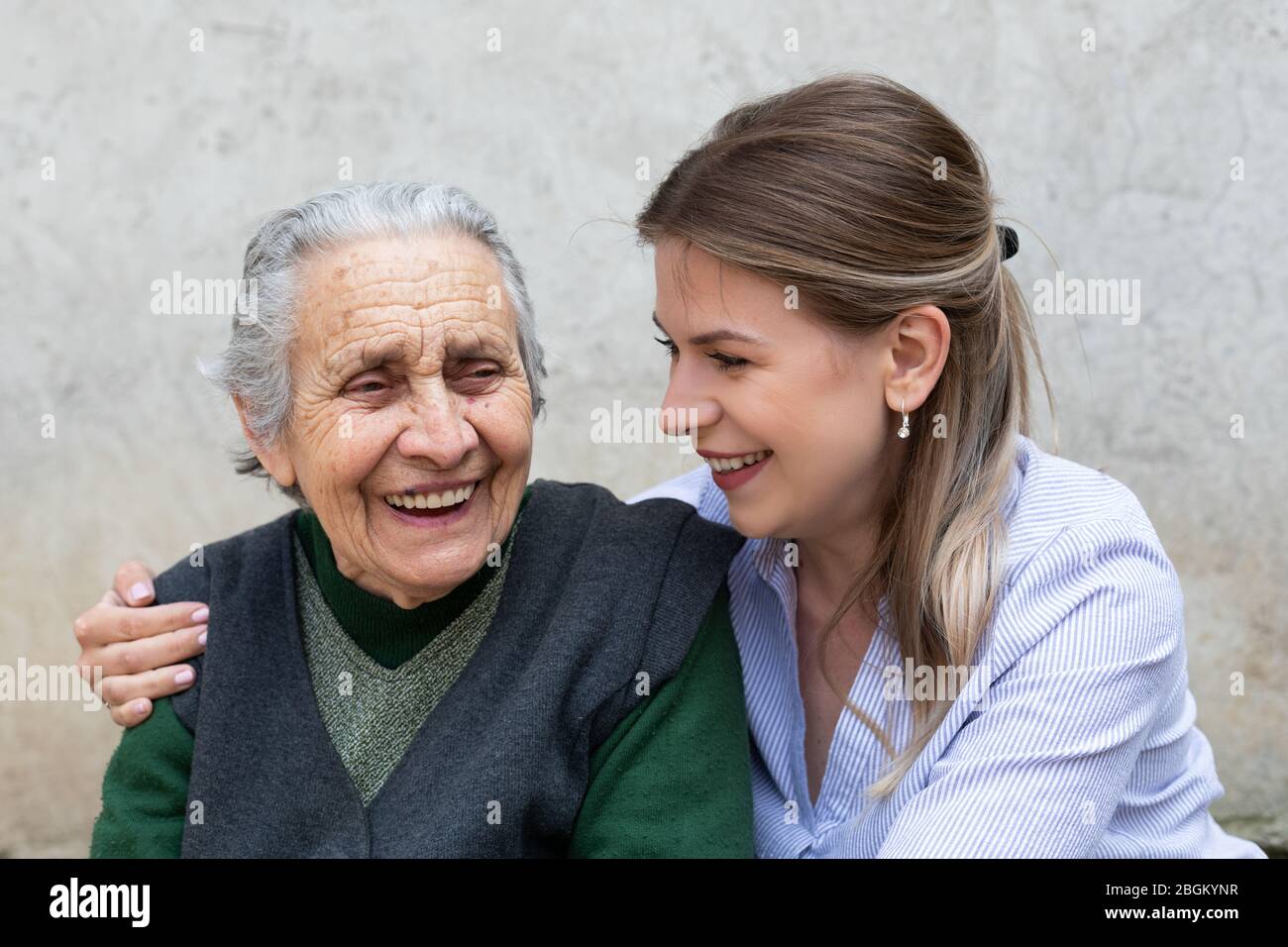 Young friendly woman embracing senior lady outdoor - quality time spent ...