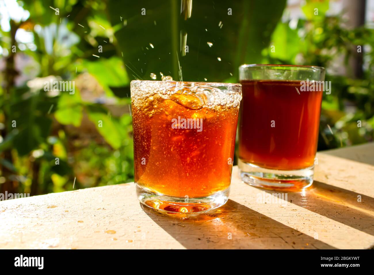 Outdoor Tea pouring into glass cup transparent with day sunlight Stock ...