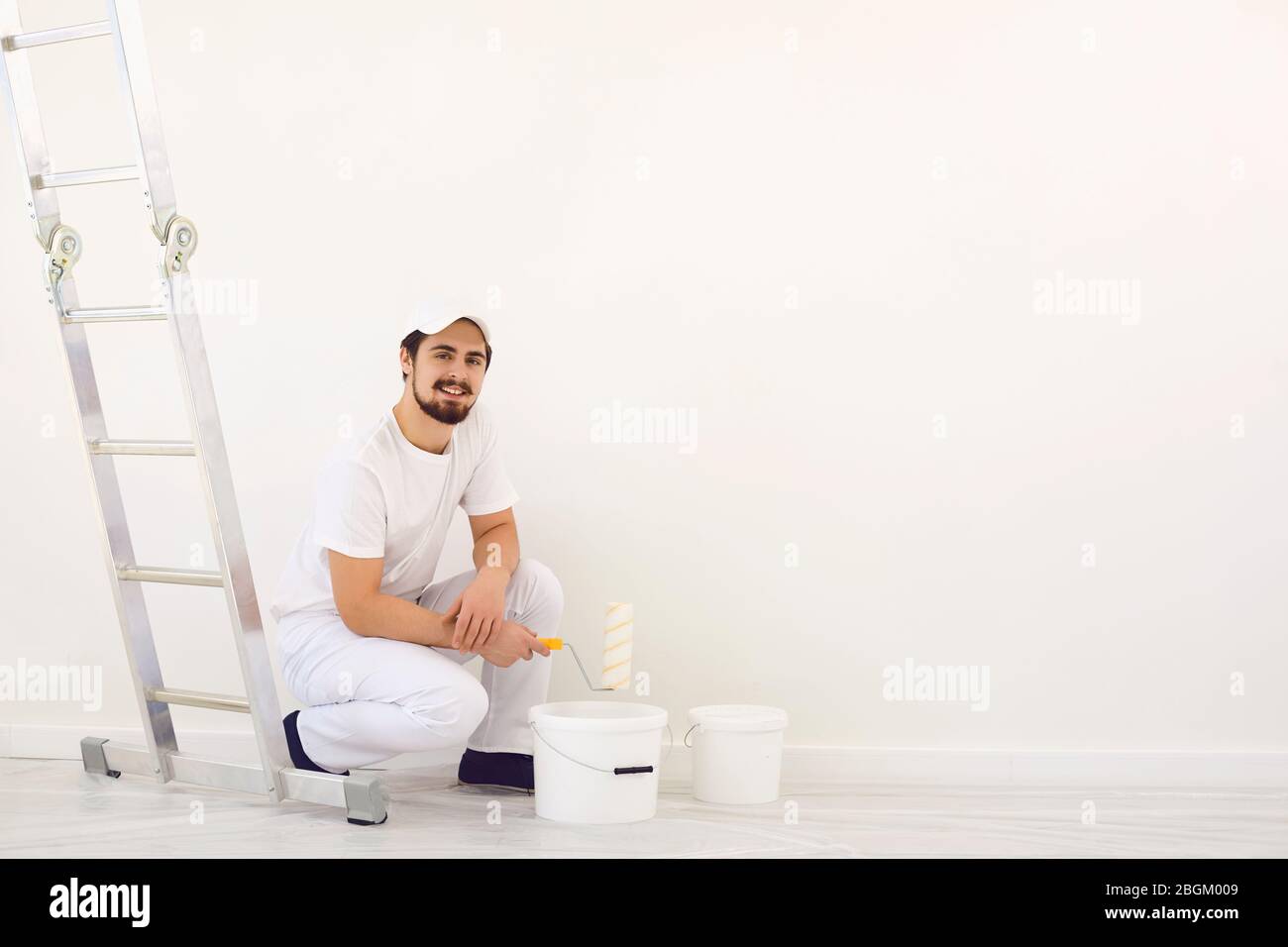 House painter in white uniform on a white background for painting in ...