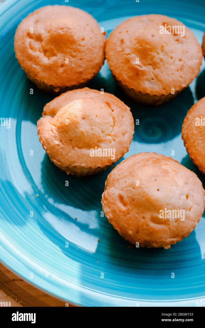 Decorated homemade muffins on a blue plate Stock Photo - Alamy