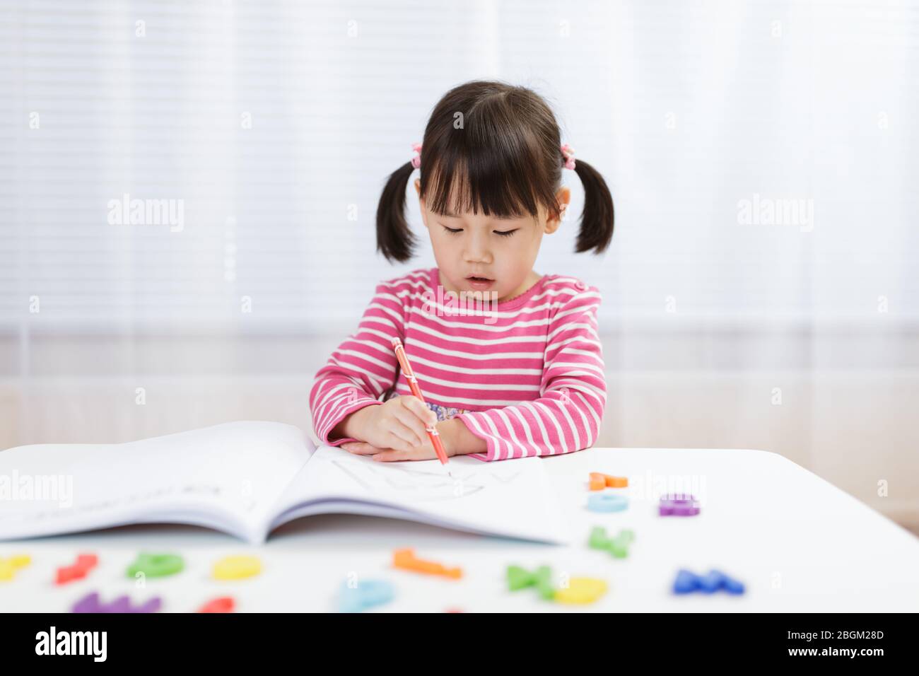 toddler girl practice writing letters for homeschooling Stock Photo - Alamy