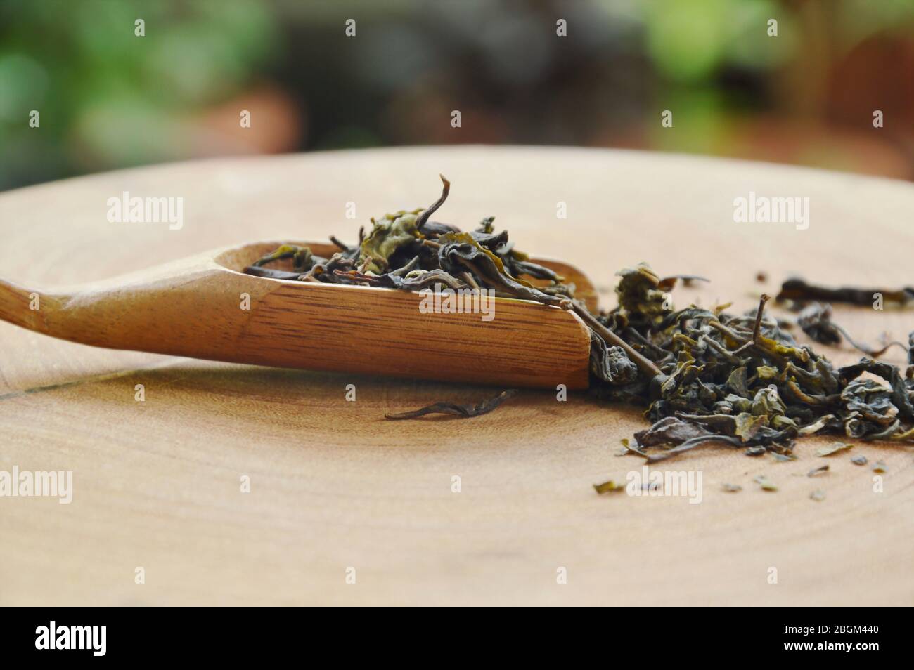 dry Chinese tea leaves in wooden scoop on chop block Stock Photo - Alamy