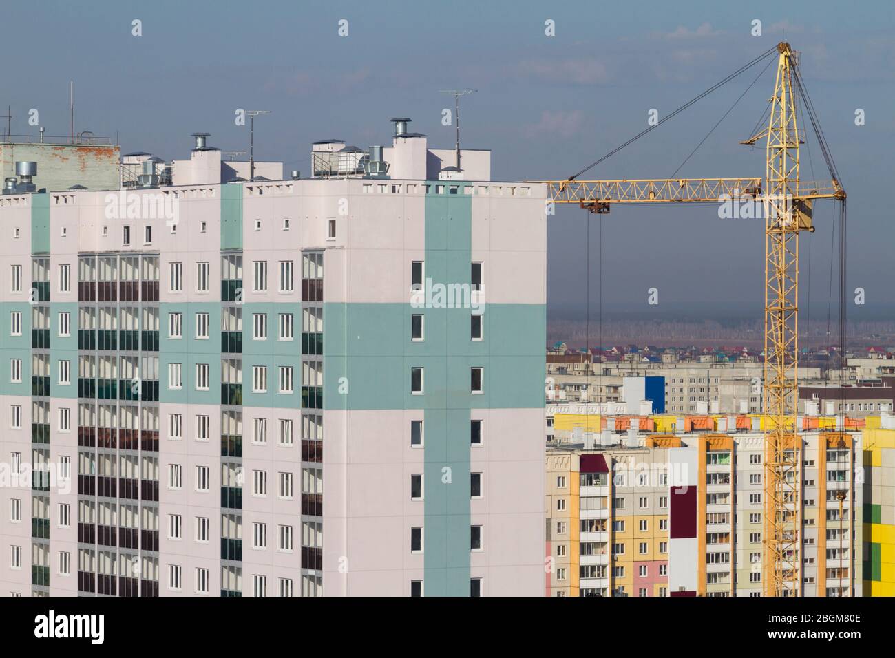 Construction crane and built multi-storey residential building against ...
