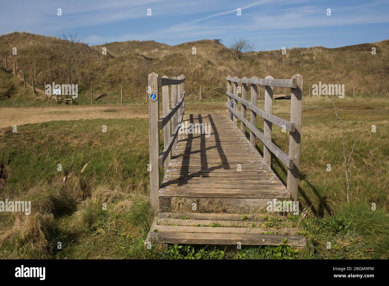 Wooden footbridge taking Wales Coast path over a tributary of the ...