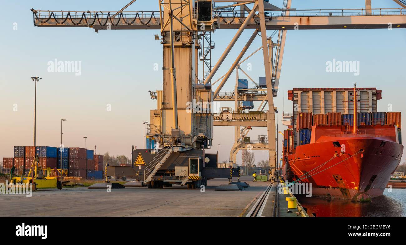 port quay at container terminal. In the background a ship with ...
