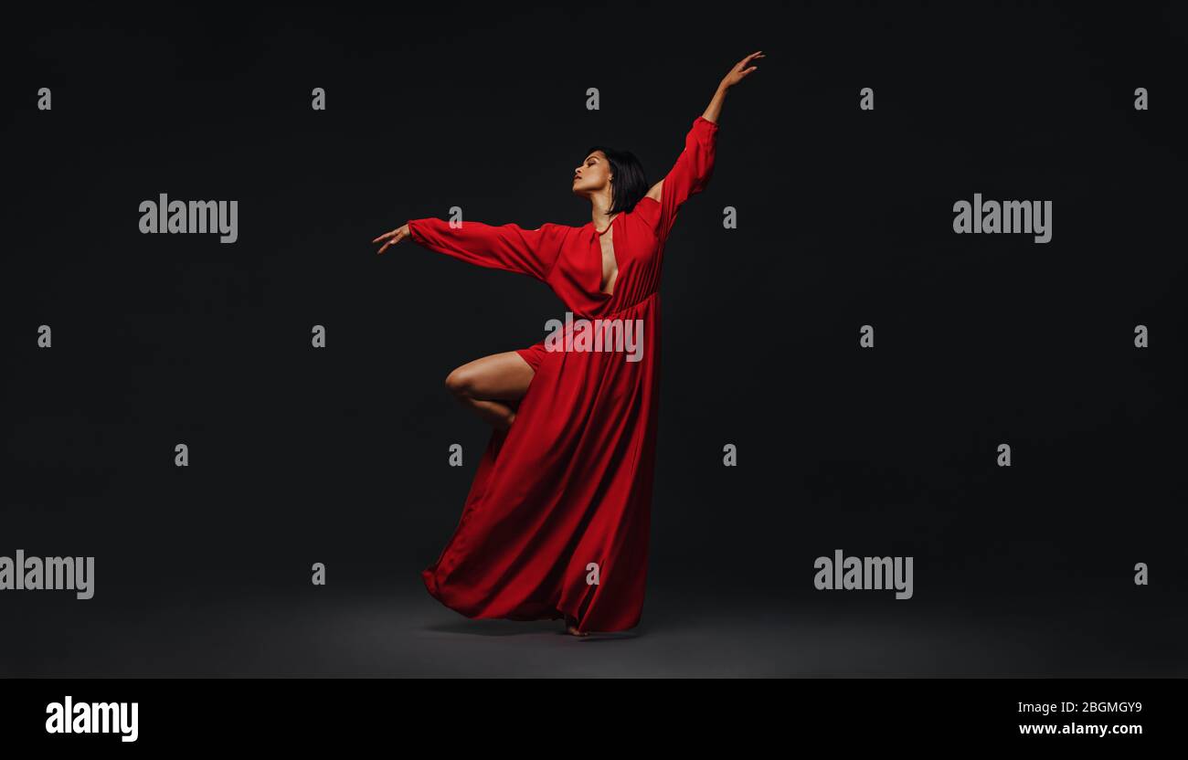 Trained contemporary female dancer dancing over black background. Young ...