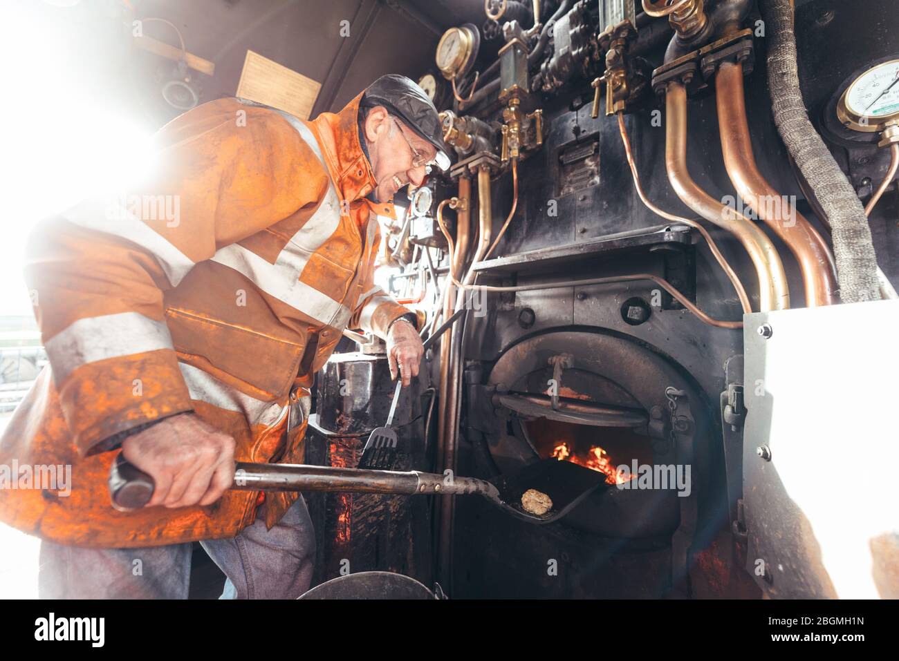 A man holding a spatula using an oiled shovel to cook food in the ...
