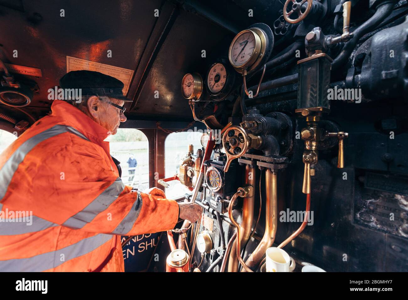 A man controlling a lever in the cab Working British steam locomotive ...
