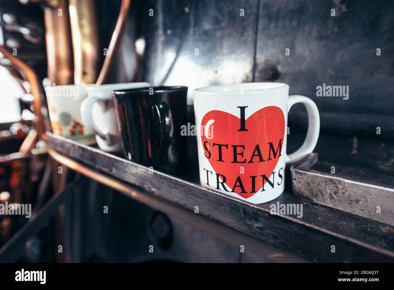A row of cups of tea in the cab, with one reading "I Love Steam Trains ...