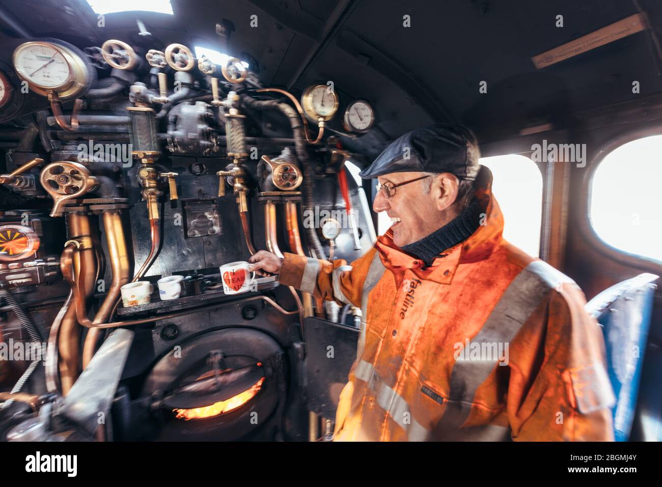 A man holding a cup of tea, which reads "I Love Steam Trains" Working ...