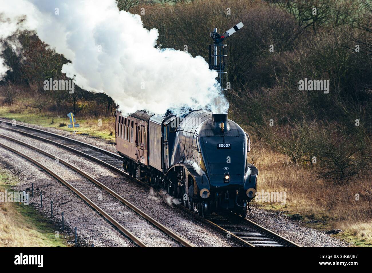 The steam train travelling along the rail tracks in full steam Working ...