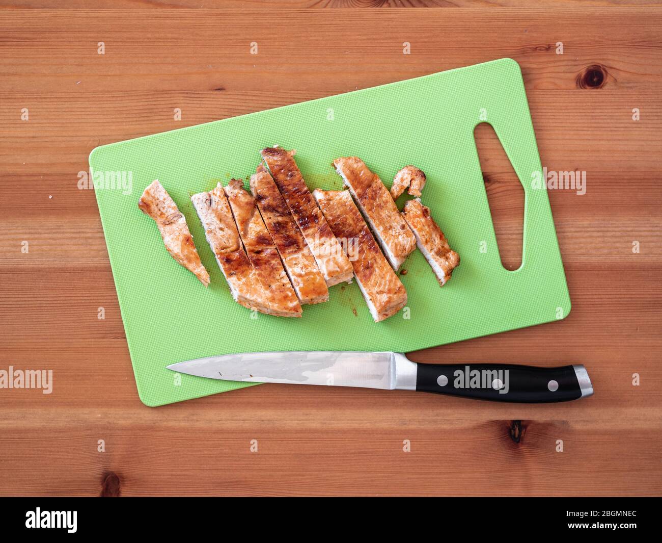 Grilled turkey meat steak sliced over wooden tabletop. Perfect ready-to ...