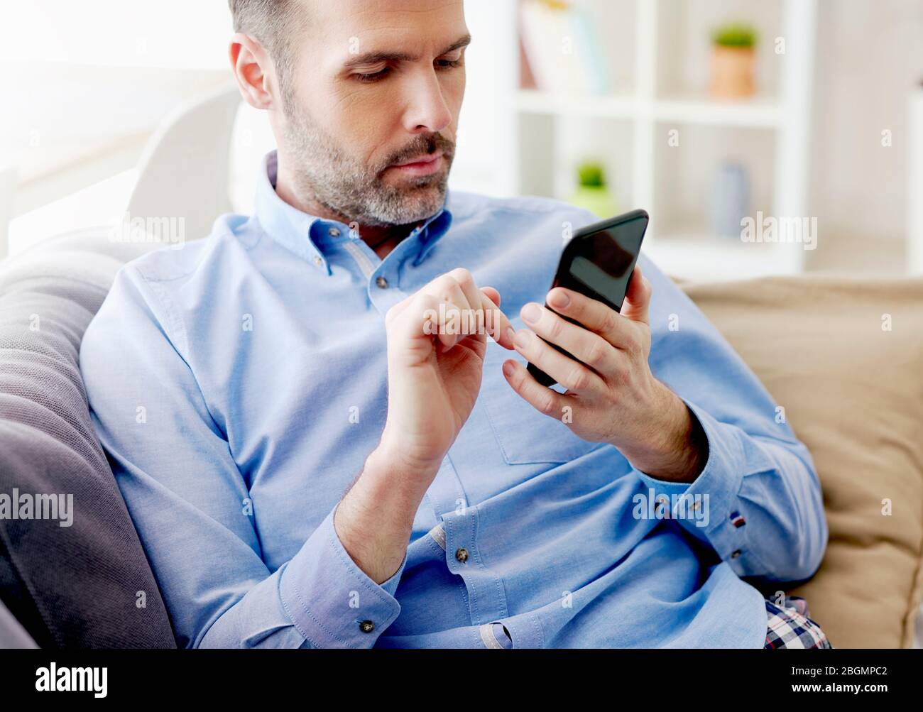 Sick man sitting on sofa hi-res stock photography and images - Alamy