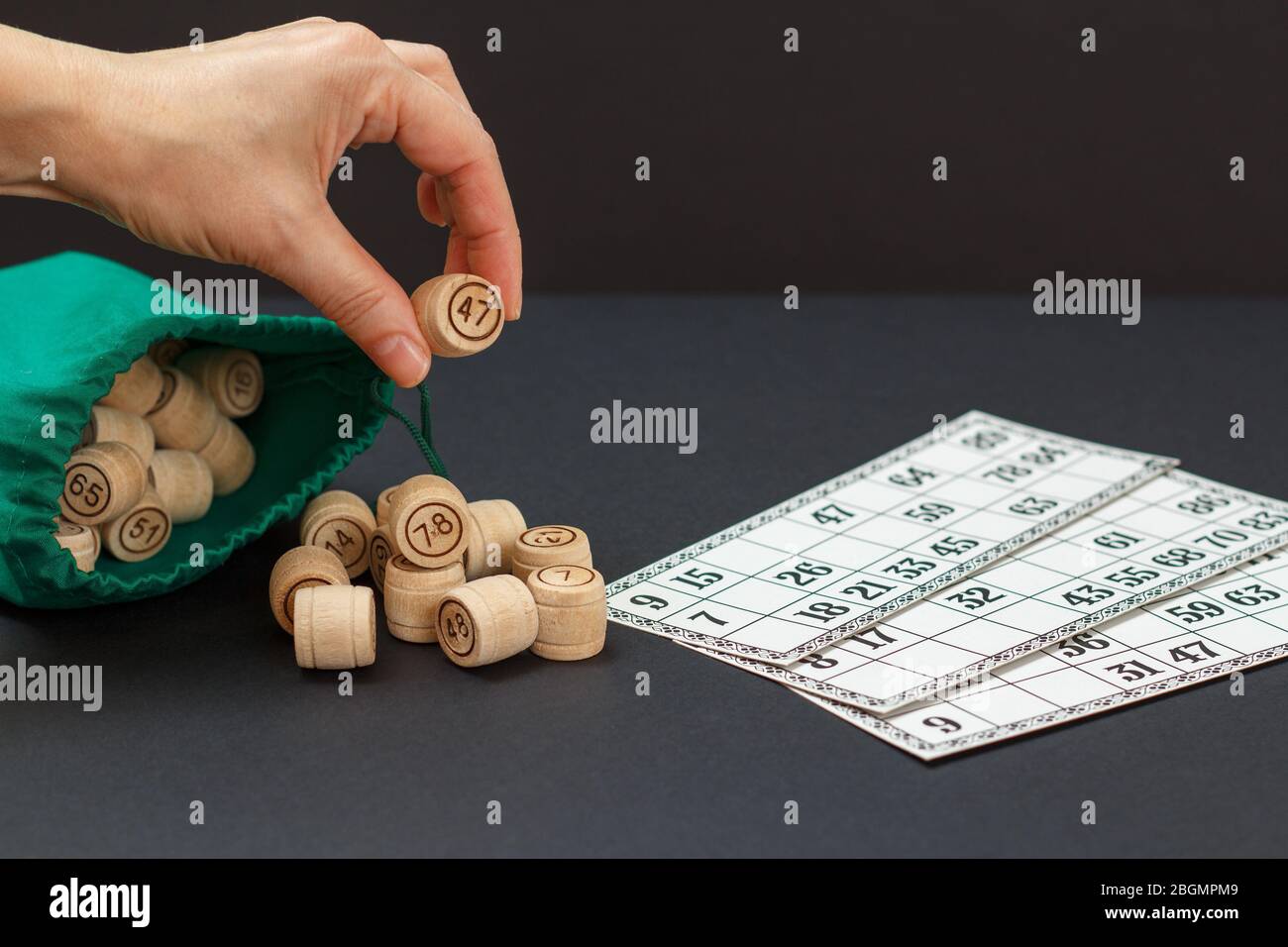 Woman's hand holding a barrel for a game in lotto. Wooden lotto barrels ...