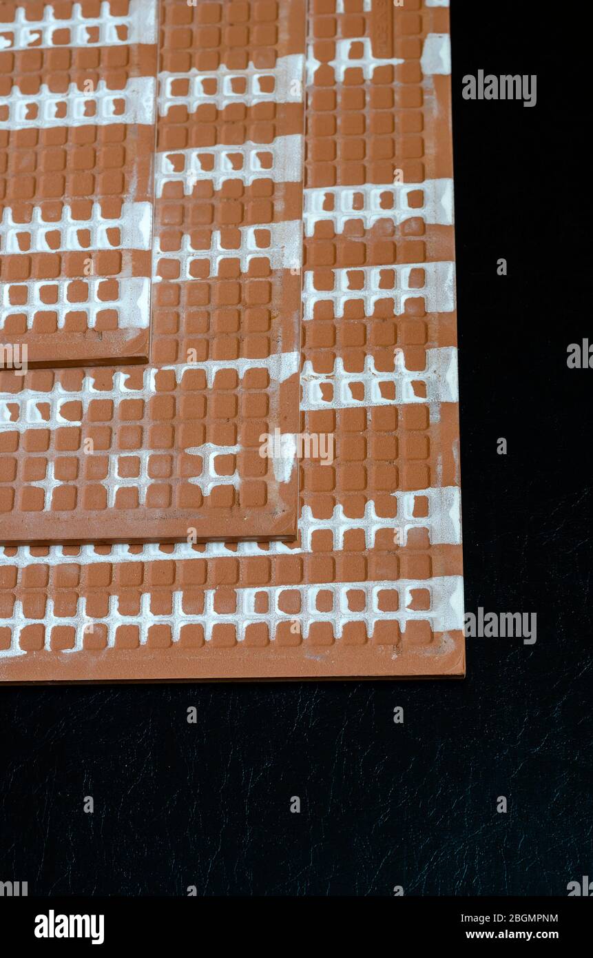 Ceramic tile back side. Three ceramic tiles on a black background. The ...