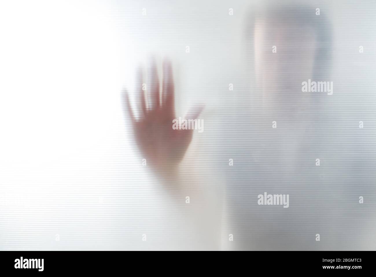 Diffused silhouette of female hands, view with shadow through plastic ...