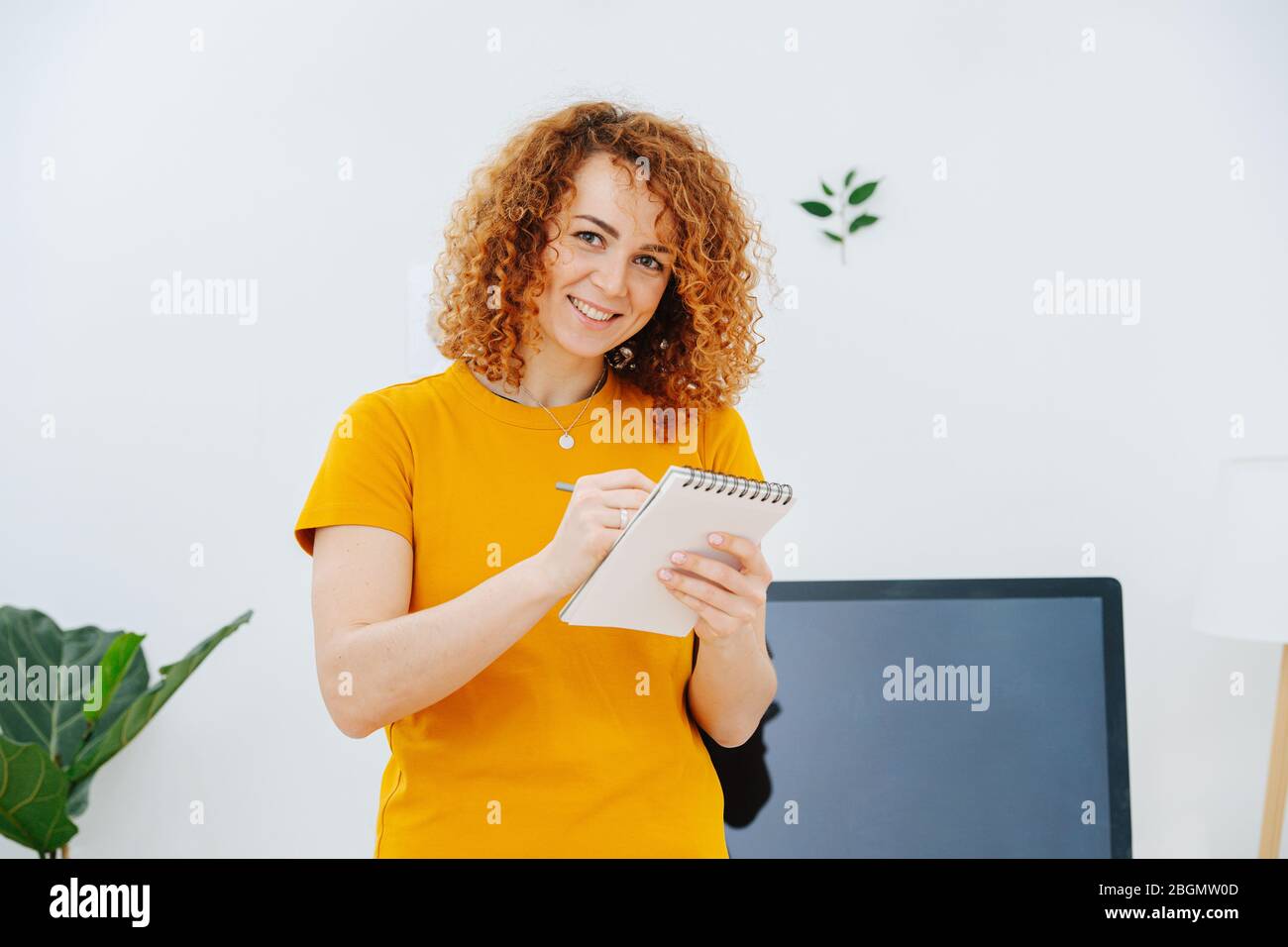 Woman drawing portrait in her notepad with crayon, smiling at camera ...