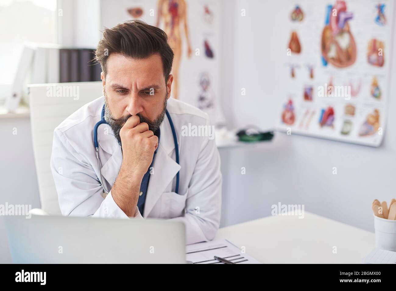 Busy doctor working with laptop in doctor’s office Stock Photo - Alamy