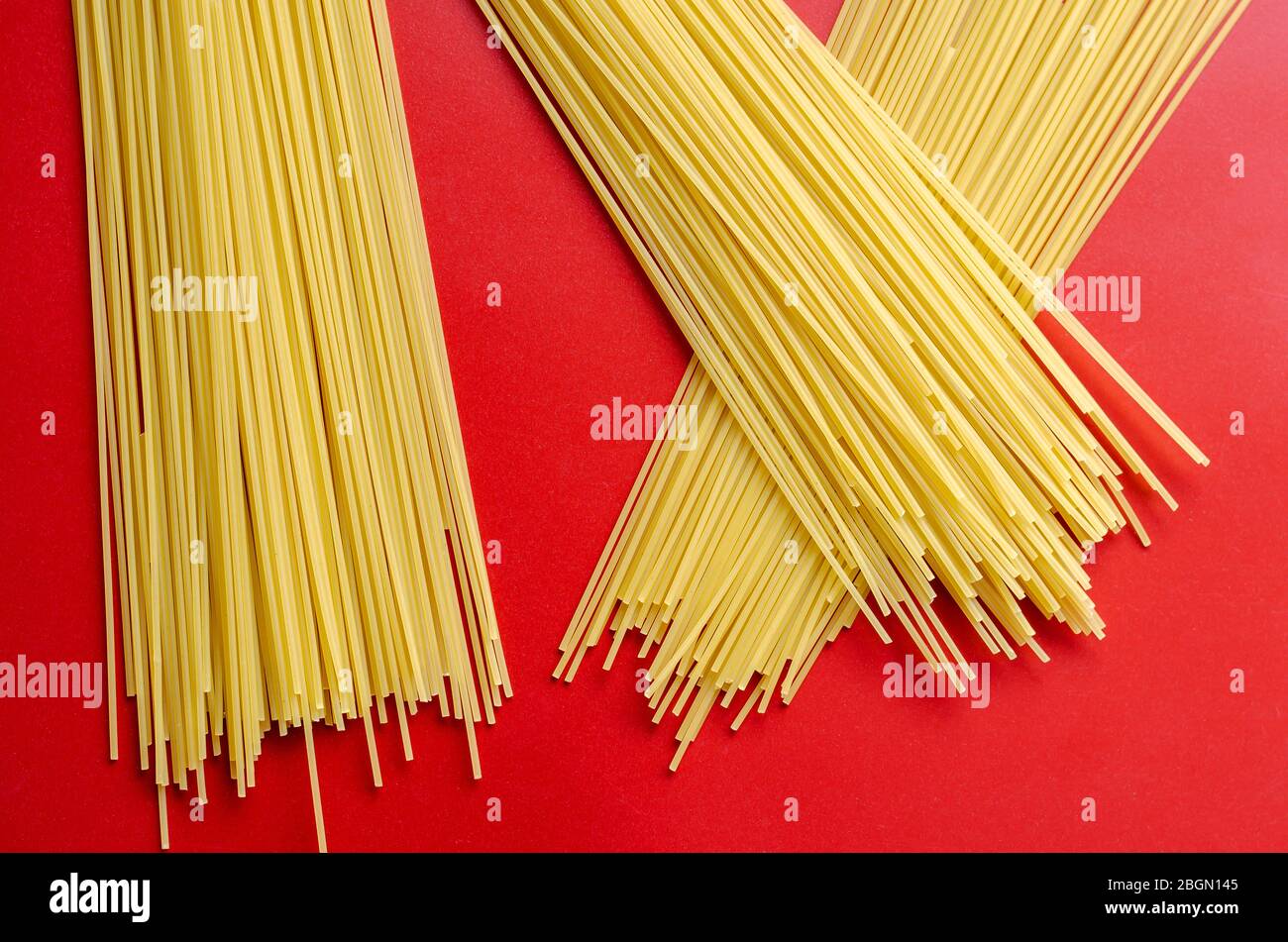 Spaghetti on a red background. Group of dry spaghetti. Unprepared pasta ...