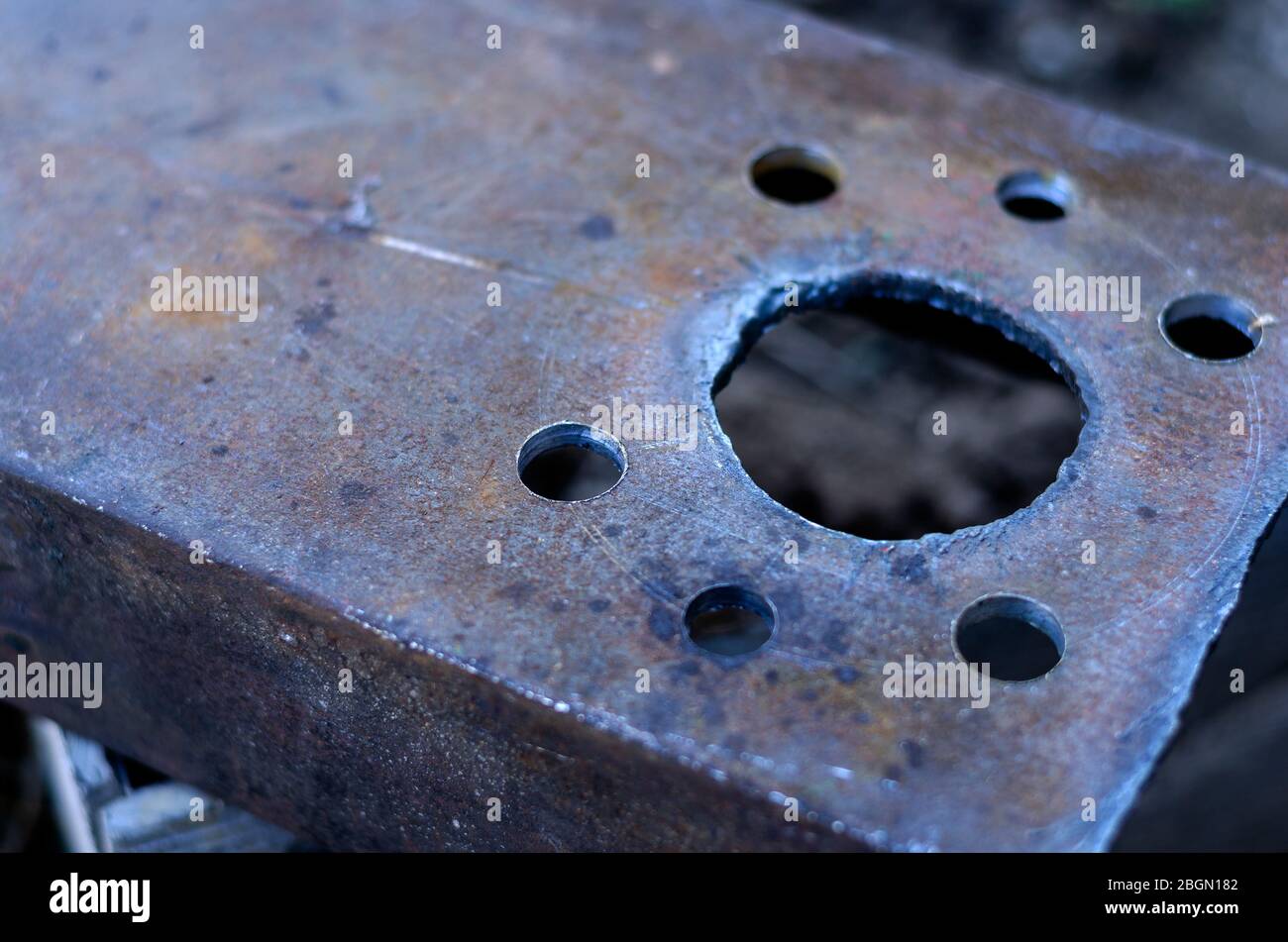 Drilled holes in the metal channel. Massive metal part with seven ...