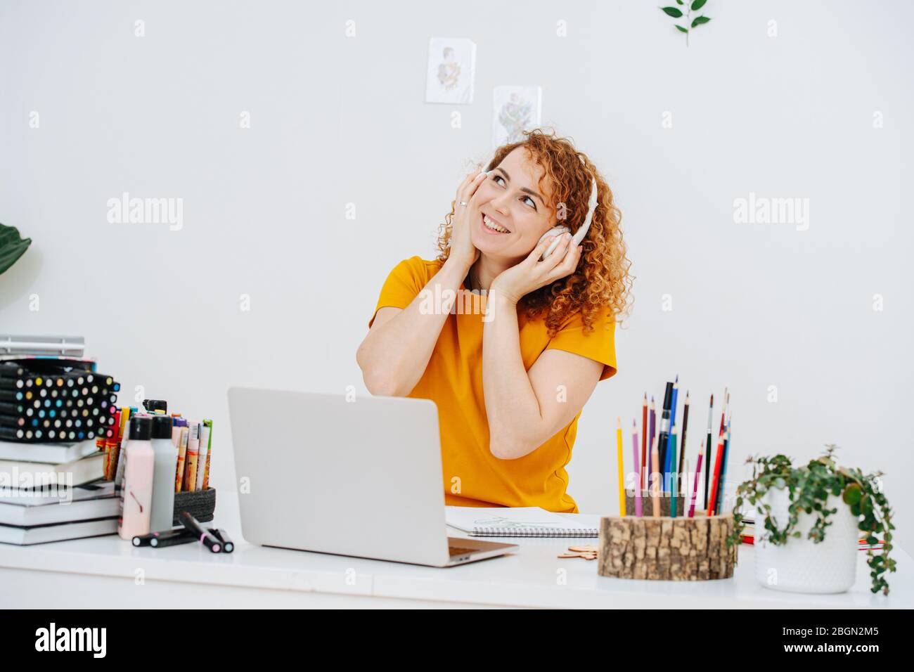 Young woman listening to music while working behind her desk Stock ...