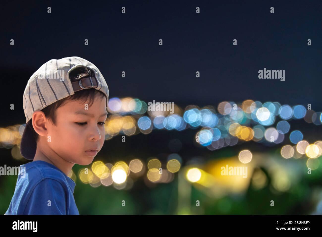 Asian boy see blurred lights of the homes on the mountain Stock Photo ...