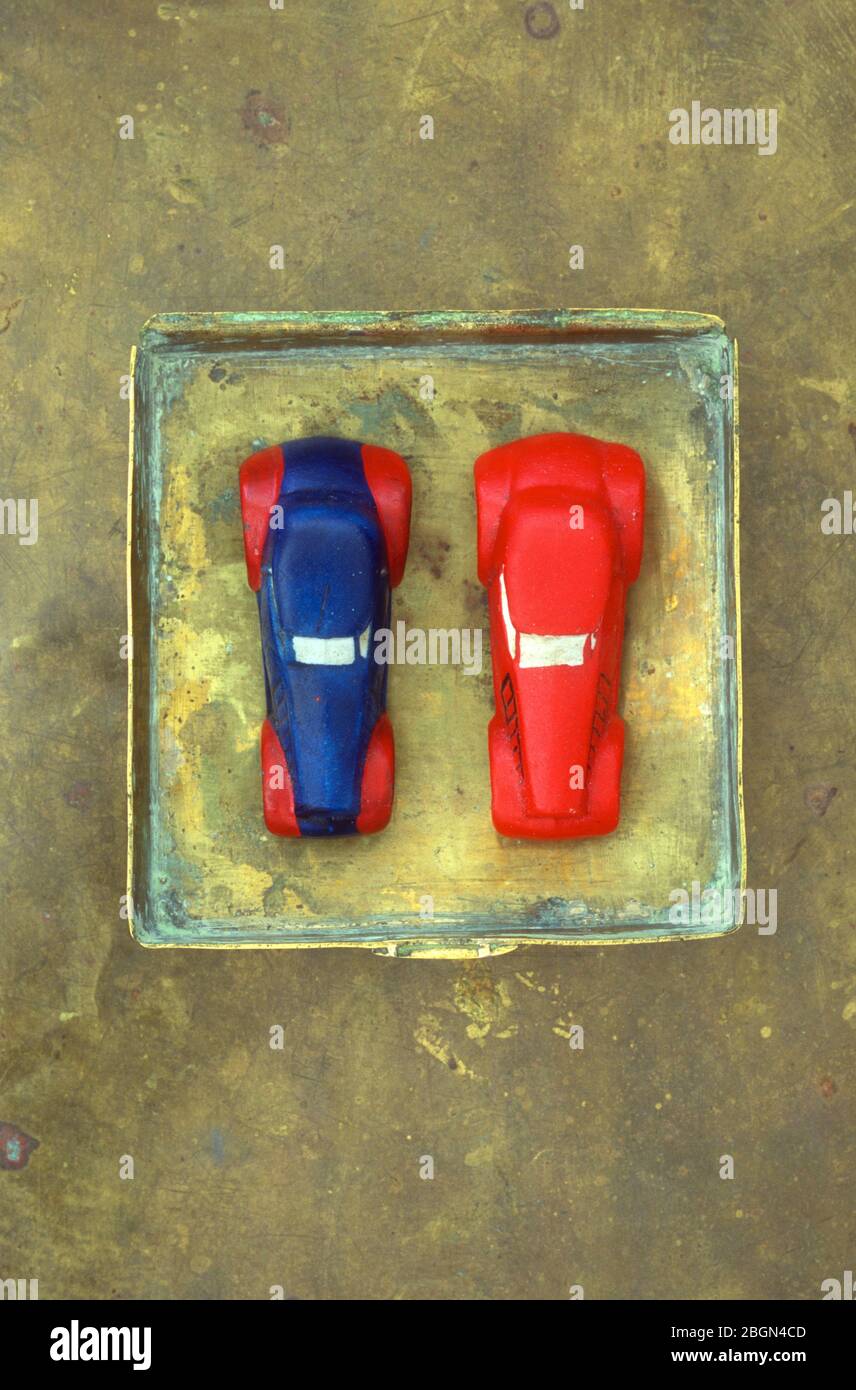 Small solid vintage models of cars one red and blue and one red lying ...
