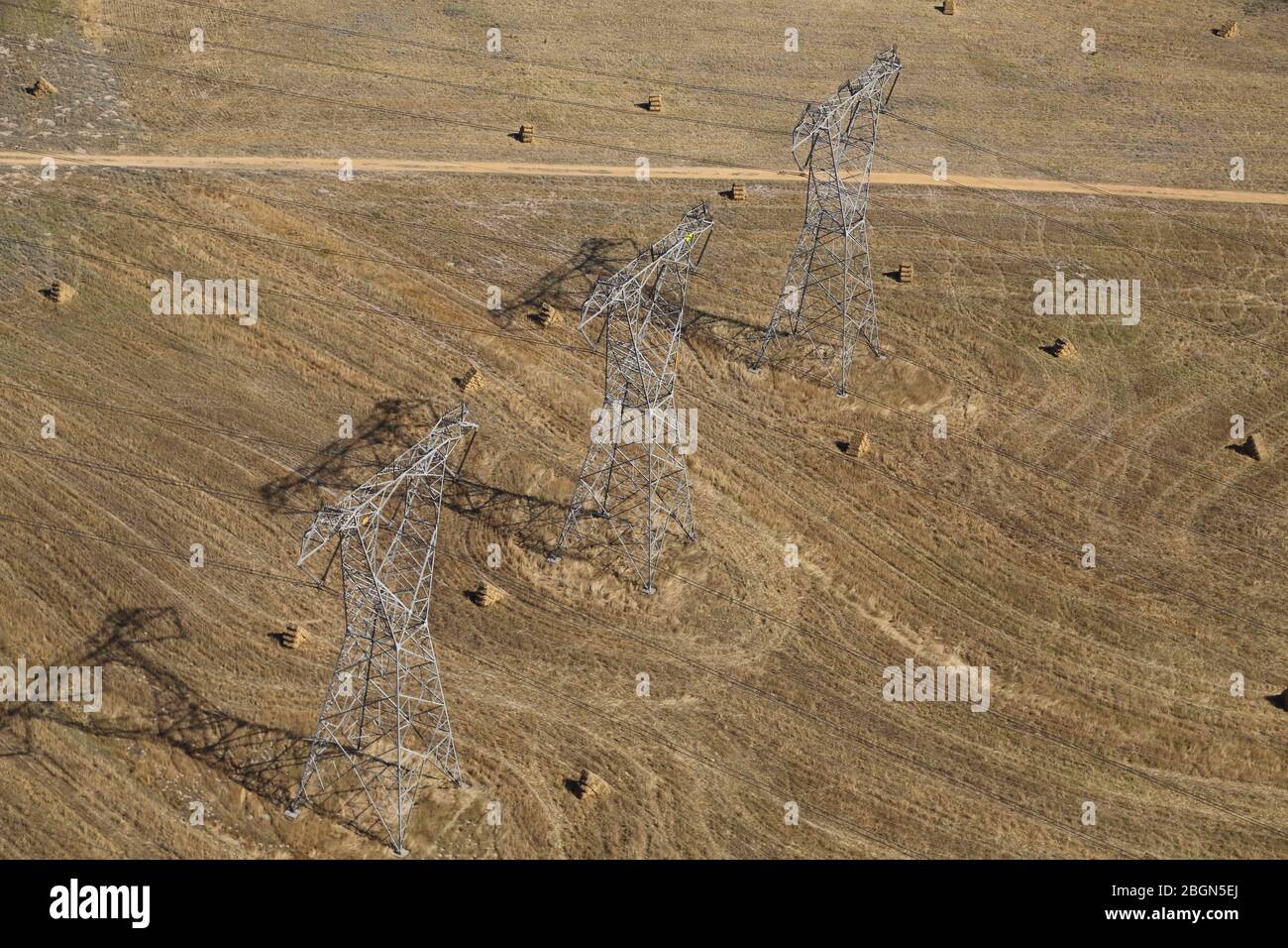 Aerial view of power lines with agricultural fields in the background ...